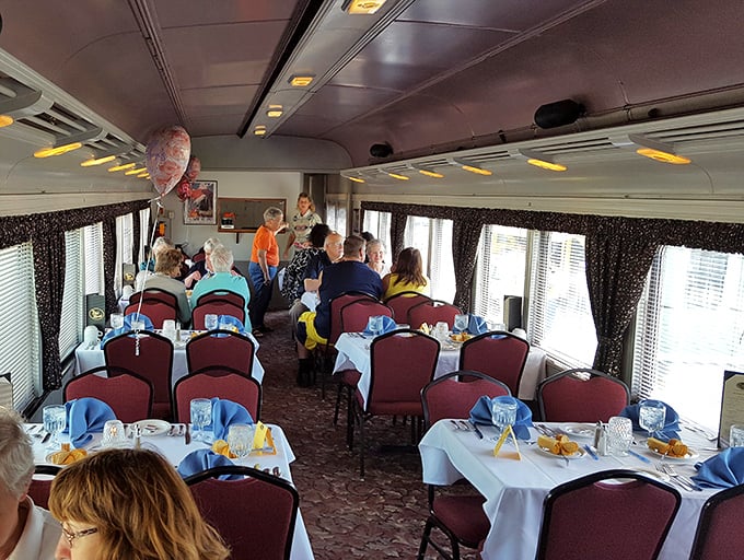 Inside the dining car, tables set with care await amateur sleuths, the burgundy chairs promising comfort during your investigation of murder most delicious.