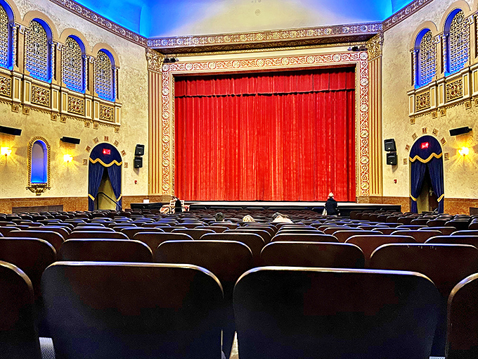 Red velvet curtains frame the stage like royal robes, waiting to part and reveal cinematic treasures to an eager audience.