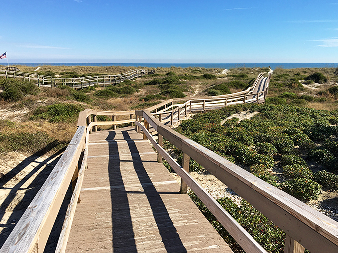 Wooden boardwalks meander through protected dunes, offering beach access while preserving the delicate coastal ecosystem. Nature's perfect compromise.