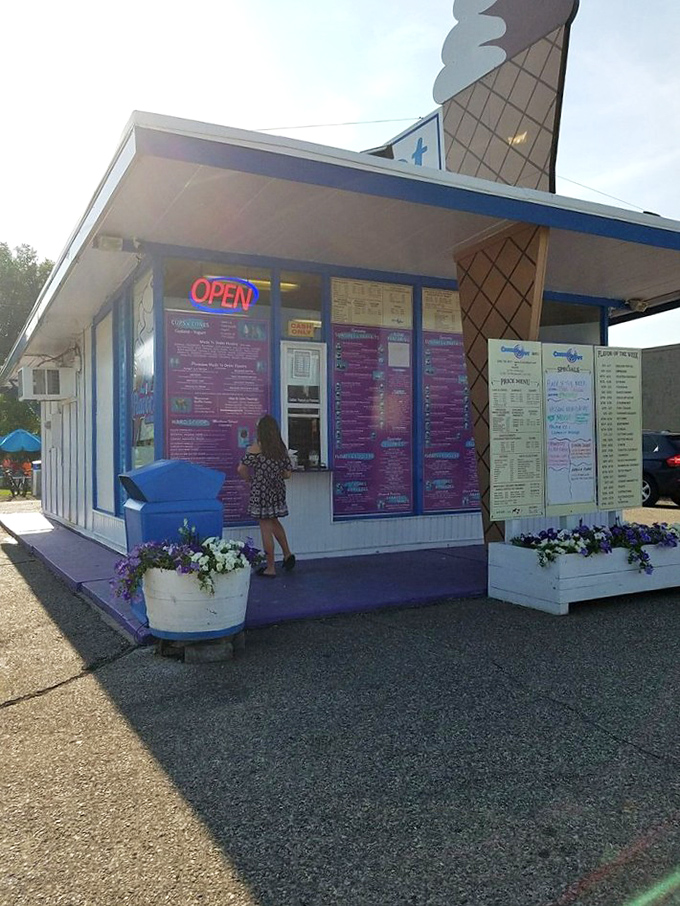 A young customer reaches for frozen bliss at the order window, where summer memories begin with a simple transaction.