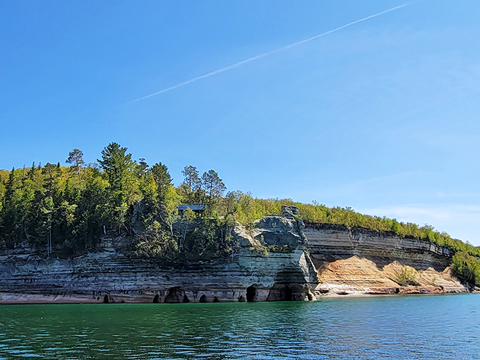 Sandstone sentinels stand guard along Michigan's northern coast, their layered stories told through bands of color and texture.