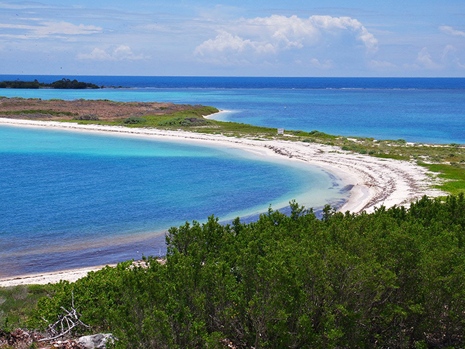 Turquoise waters curve around pristine white sand at Dry Tortugas, where isolation creates paradise 70 miles from civilization.