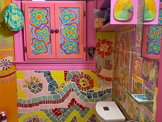 Even the bathroom refuses to be boring, with pink cabinets and mosaic walls turning everyday functions into an artistic experience.