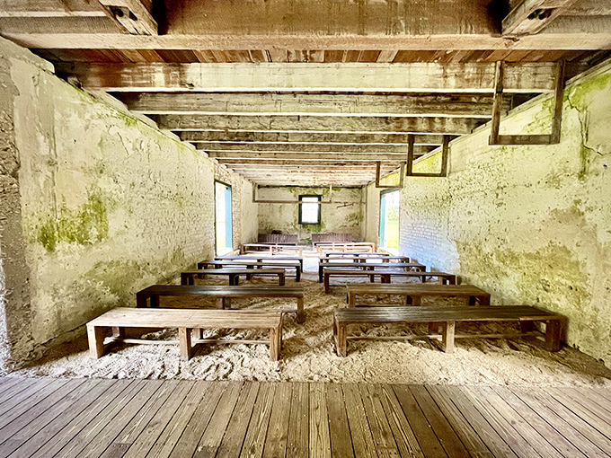 Simple wooden benches fill what was once a place of worship, the sparse interior speaking volumes about lives lived in captivity.
