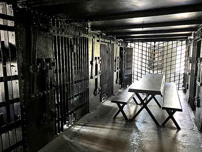 The stark prison dining area where inmates once gathered for meals, featuring original benches and tables that witnessed decades of jailhouse conversations.
