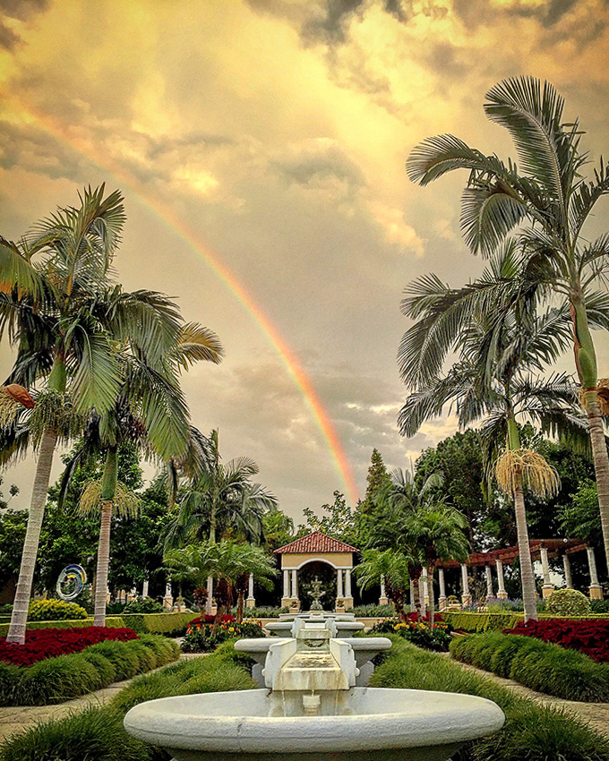 Nature's own light show! A rainbow arches over the central garden vista, as if the universe decided this paradise needed extra decoration.