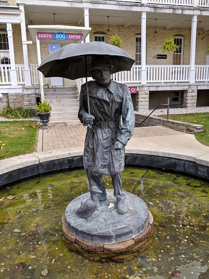 A contemplative bronze figure stands eternally in the rain, umbrella raised – a poignant artistic nod to the building's past as a place of shelter and healing.