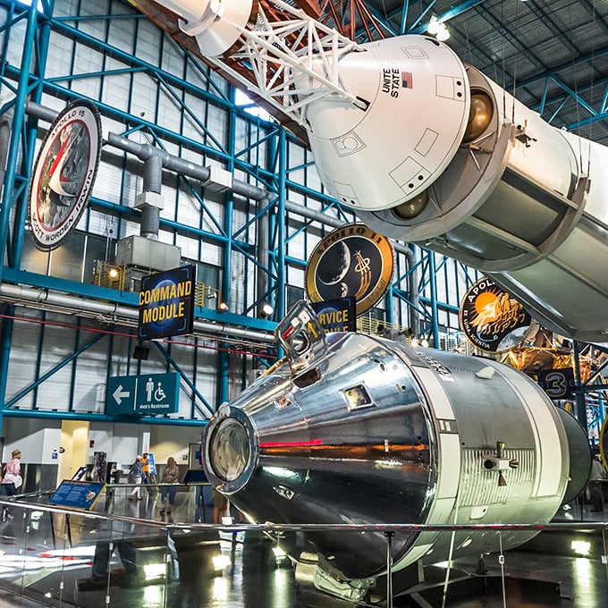 The Apollo command and service modules hang suspended overhead, their weathered exteriors telling silent stories of cosmic journeys and fiery returns.