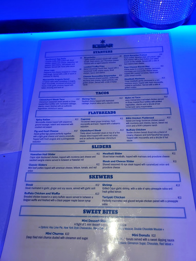 The menu glows with tempting offerings under blue light &ndash; from loaded truffle fries to churros, perfect for refueling between cold and hot zones.