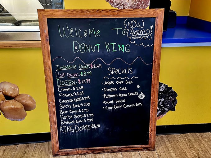 The chalkboard menu tempts with offerings from classic glazed to seasonal specialties like pumpkin cake and apple cider donuts.