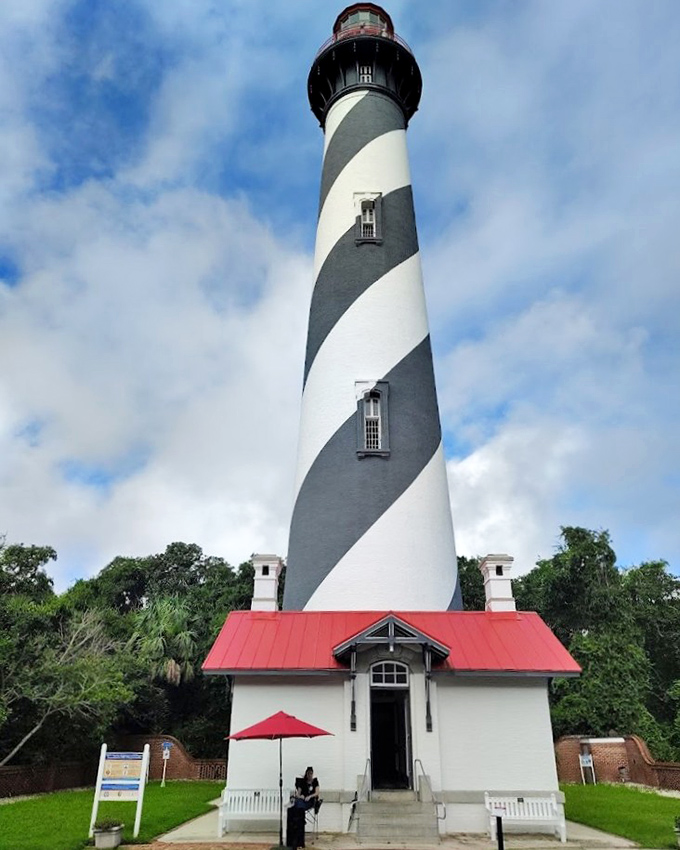 The classic barber-pole pattern of St. Augustine Lighthouse creates a striking silhouette against the waterfront, drawing visitors up its 219 steps for panoramic views.