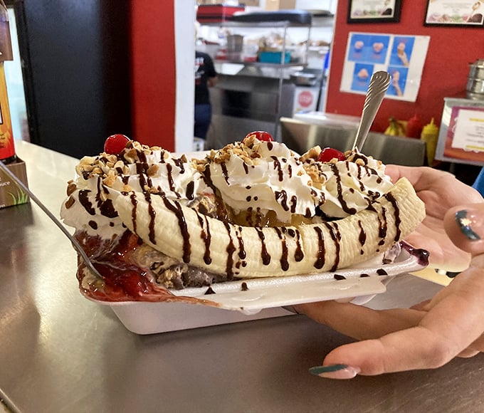 This banana split isn't just dessert—it's an architectural marvel of joy with mountains of whipped cream and rivers of chocolate sauce.
