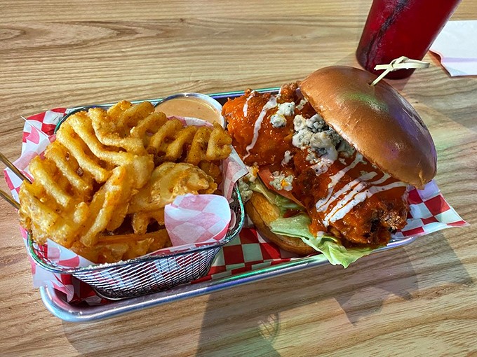 This Buffalo chicken sandwich brings the heat with crispy coating, tangy sauce, and blue cheese crumbles &ndash; served with perfectly golden fries.