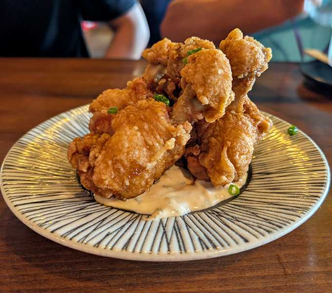 Golden-fried chicken nuggets nestled on creamy sauce &ndash; proof that sometimes the simplest pleasures are the most profound.
