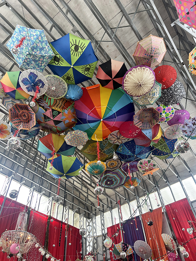 Look up! A kaleidoscopic canopy of umbrellas transforms an ordinary ceiling into an upside-down wonderland of color and whimsy.