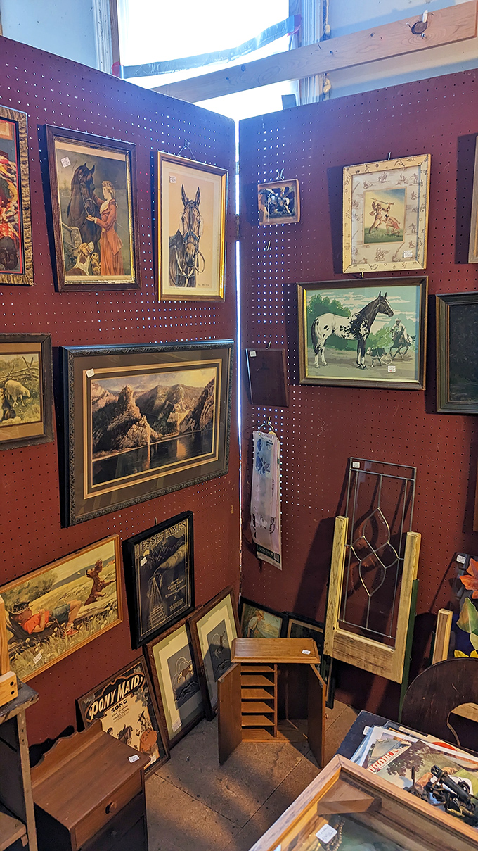 The wall of vintage frames creates an eclectic gallery, where horse portraits and landscape scenes transport visitors to bygone eras with every glance.