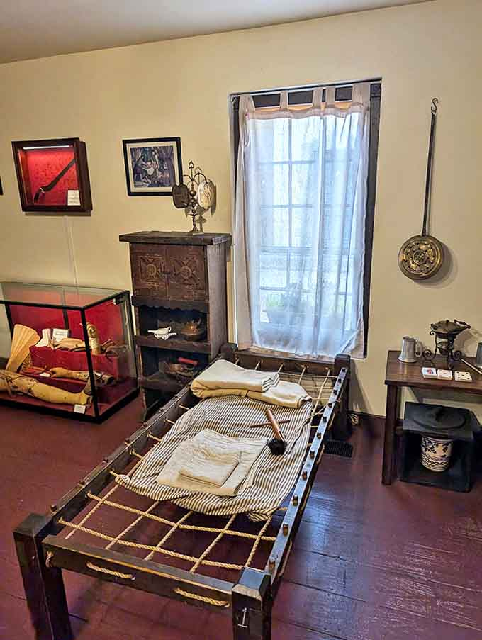 Simple rope beds and sparse furnishings show the stark reality of colonial patient care. Sleep tight? Not with these medical practices!
