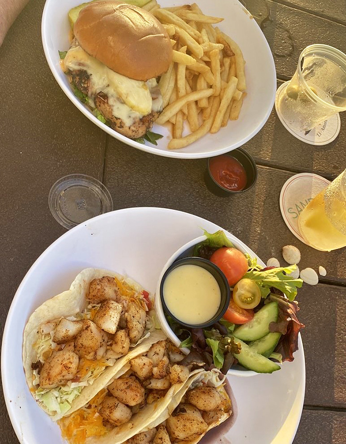 Beach day perfection: A juicy sandwich with crispy fries alongside fish tacos that taste like vacation on a plate.