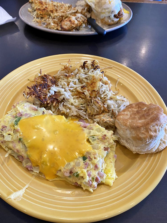 This isn't just any omelet &ndash; it's a fluffy yellow canvas painted with ham and cheese, accompanied by hash browns crisped to golden perfection.