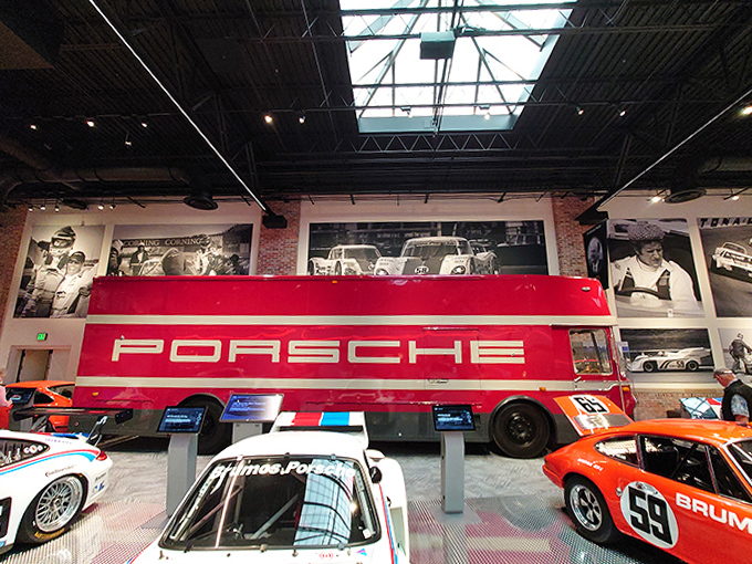 The massive Porsche transport truck towers over its charges like a mother hen, except this hen carried race cars to victory instead of eggs.