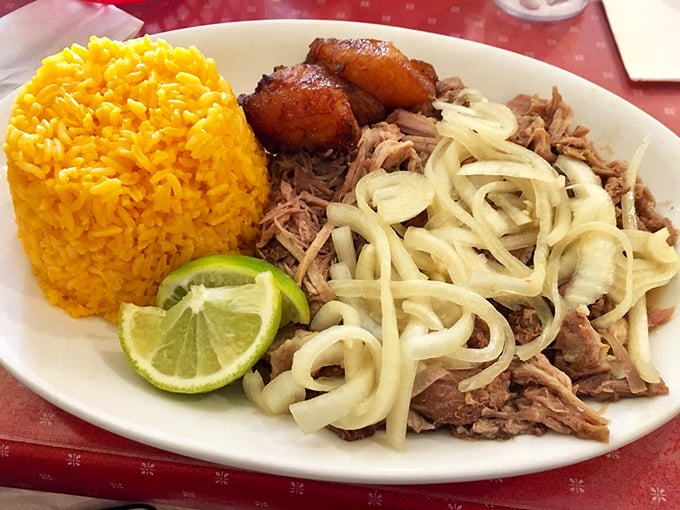 This isn't just roast pork &ndash; it's a masterclass in patience and flavor. Tender, juicy meat with onions atop sunny yellow rice and sweet plantains.