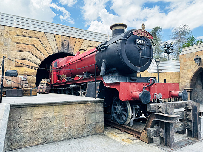 Sunlight streams through the station's glass ceiling, casting dramatic shadows around the mighty steam locomotive.