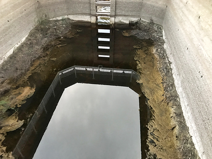 Looking down into the empty basin where magical waters once bubbled, now just a concrete shell holding memories.