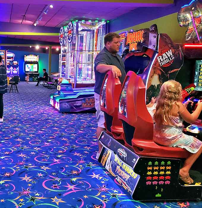The arcade's carpet, a cosmic explosion of stars and swirls, has witnessed countless quarters sacrificed in pursuit of high scores.