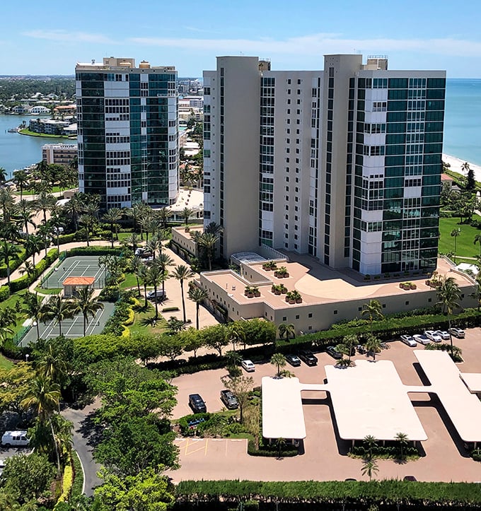 Modern high-rise condominiums stand sentinel along Naples' coastline, their reflective windows capturing the brilliant Florida sunshine.