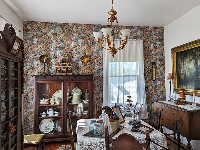 Floral wallpaper embraces this dining room like an enthusiastic aunt, while china cabinets stand guard over delicate teacups awaiting their next ghostly tea party.