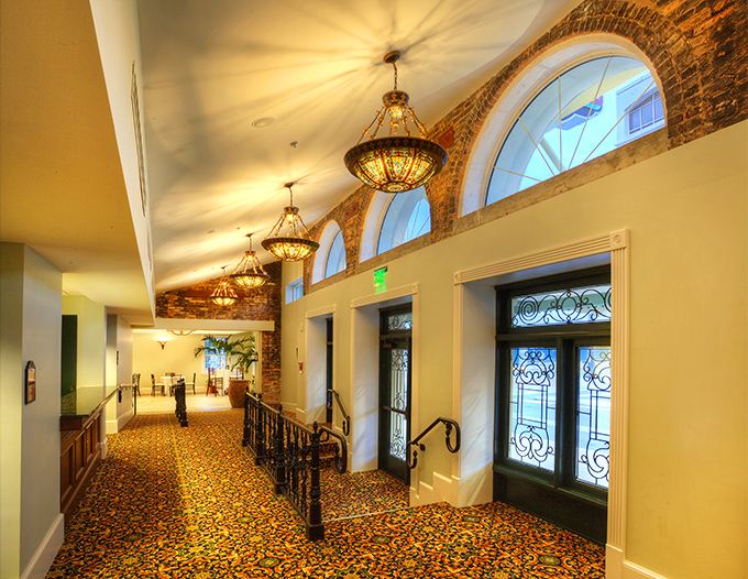 Elegant chandeliers illuminate the patterned carpet of the theater's hallway, where staff have reported mysterious footsteps after hours.