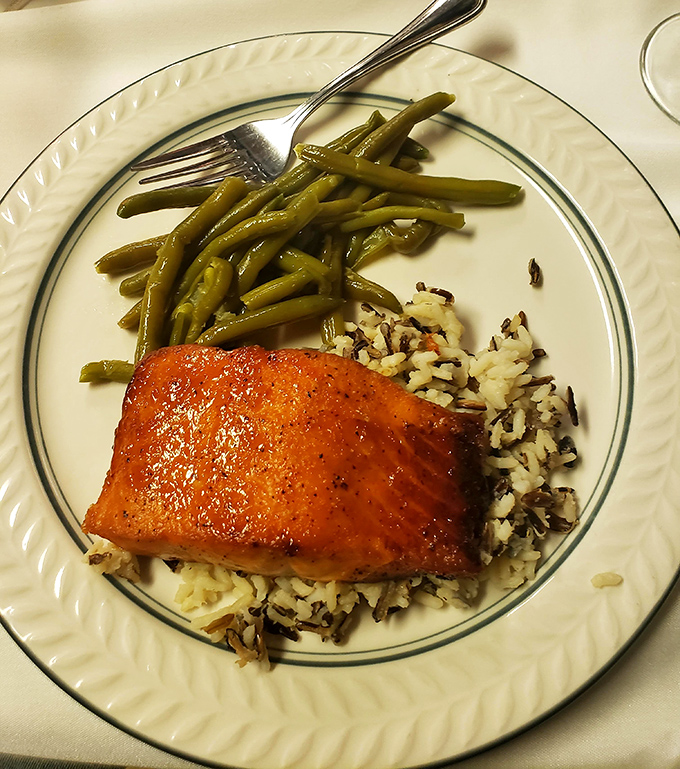 Glazed salmon perched atop wild rice makes its case for dinner perfection, with green beans standing at attention like loyal alibis.