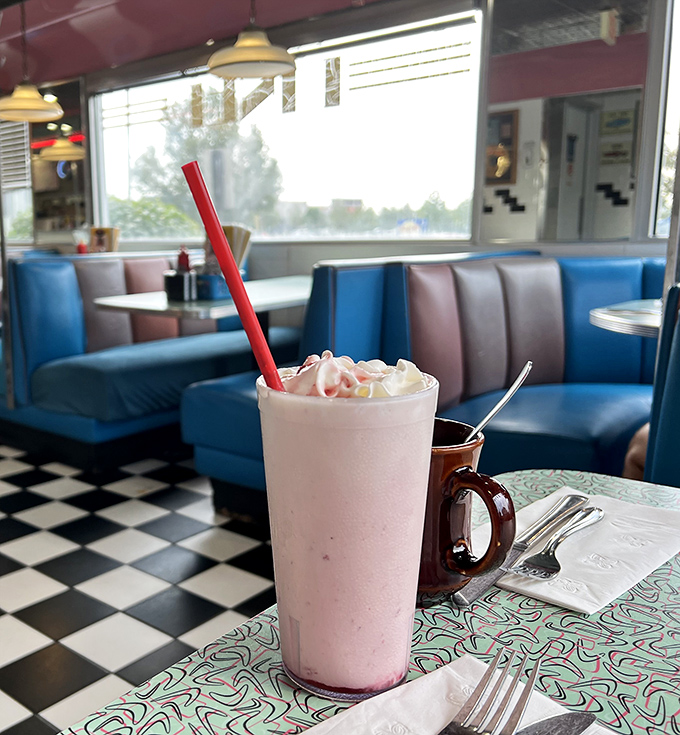 This isn't just any strawberry milkshake &ndash; it's a pink tower of dairy perfection with a red straw standing at attention, ready for your first heavenly sip.