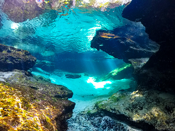Beneath the surface lies another world entirely &ndash; a crystal kingdom where sunlight dances through water clear enough to count sand grains.