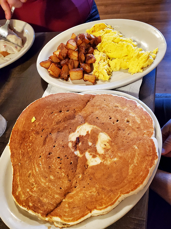The breakfast trinity &ndash; fluffy eggs, crispy potatoes, and pancakes that could double as a tablecloth. Morning perfection on a single plate.