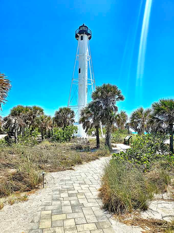 The Gasparilla Island Lighthouse rises majestically among palm trees, a white exclamation point against Florida's blue sky.