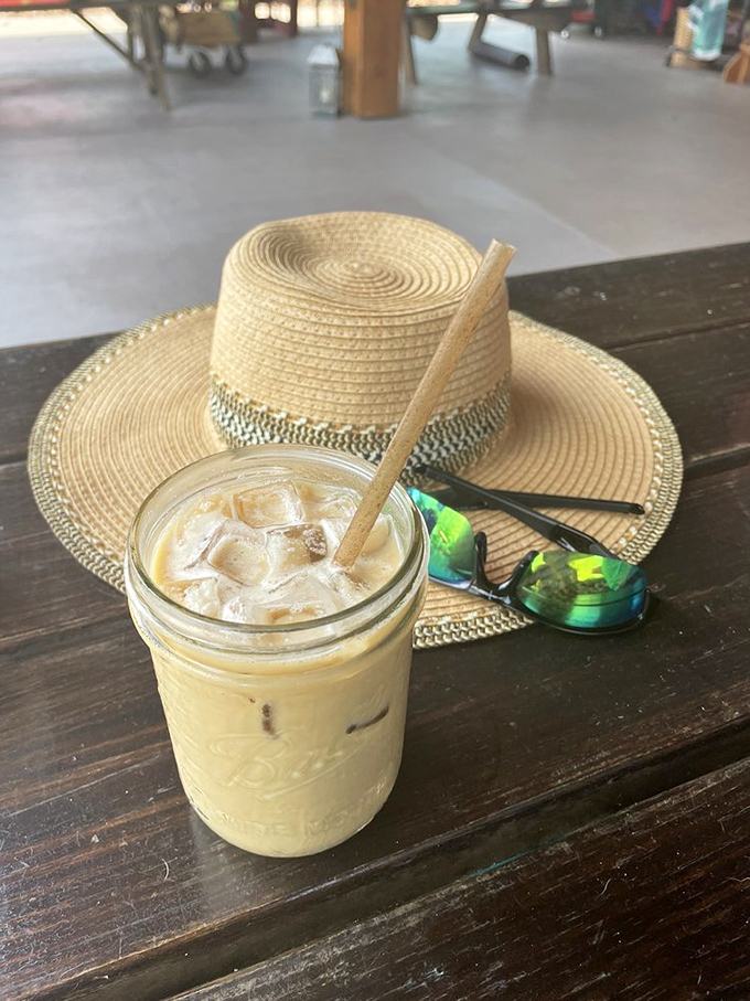 A perfectly crafted iced latte sits beside a stylish straw hat and sunglasses &ndash; the essential Florida dog park accessory trio.