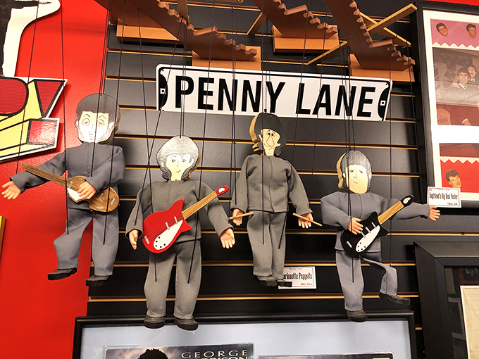 These puppet Beatles dangle beneath the iconic Penny Lane sign, capturing the whimsical spirit that made the Fab Four so beloved.