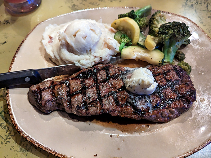 The New York Strip arrives perfectly grilled with a pat of butter melting atop &ndash; carnivores rejoice at this Jurassic-sized portion.