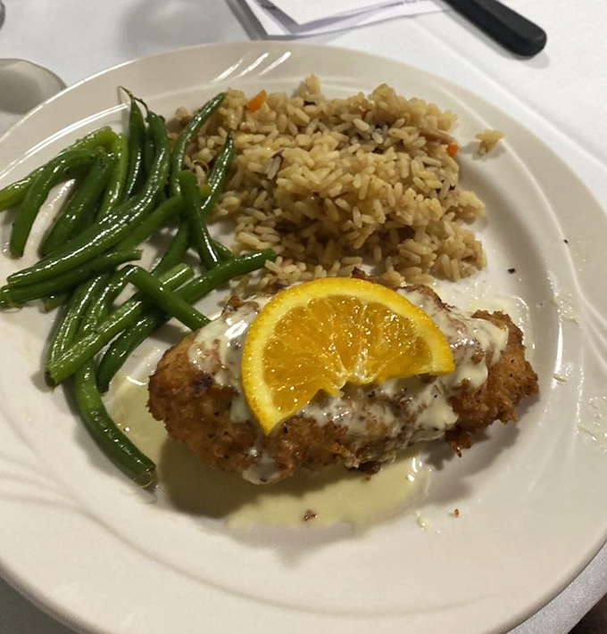 The chicken entr&eacute;e arrives with a bright citrus accent, perfectly paired with wild rice and green beans that retain their garden-fresh snap.