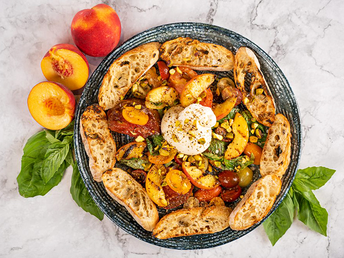 A beautiful alliance of sweet peaches, heirloom tomatoes and creamy burrata, surrounded by crusty bread soldiers ready to scoop up every last delicious bite.