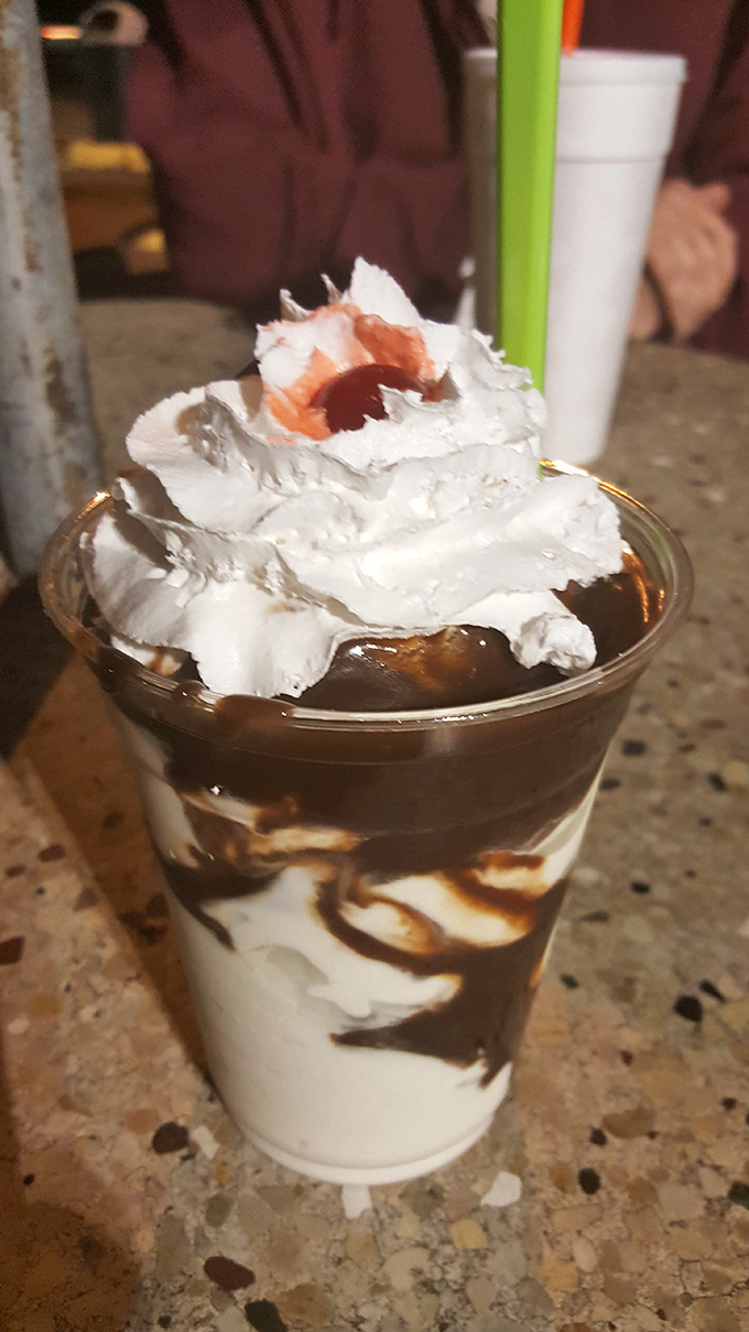 This chocolate parfait isn't just dessert, it's architecture &ndash; layers of vanilla, chocolate, and whipped cream creating a skyscraper of sweetness topped with a cherry penthouse.