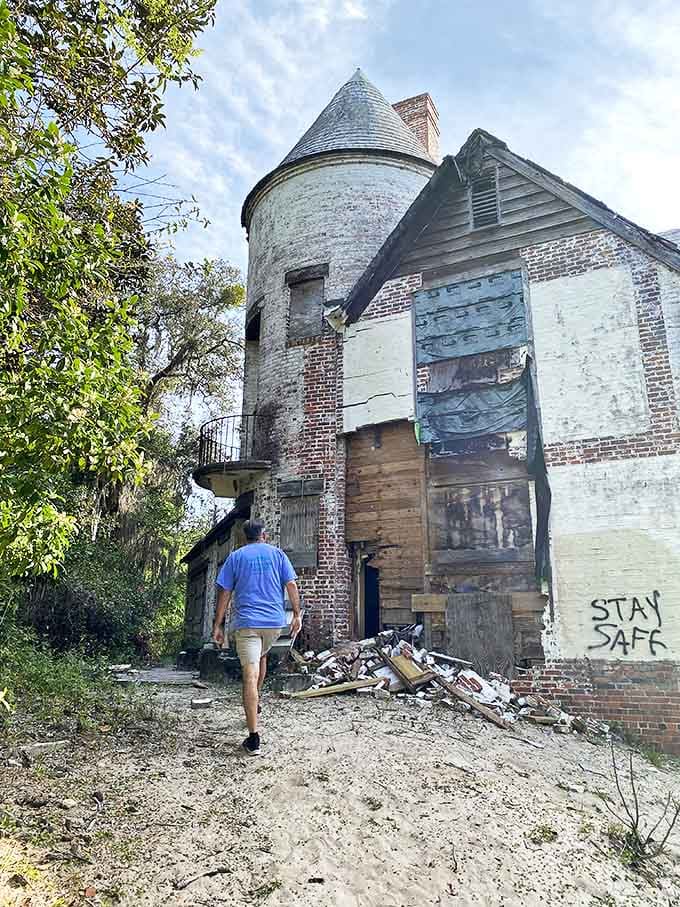A visitor approaches the mansion cautiously, perhaps wondering if the stories of strange phenomena and ghostly encounters might actually be true.