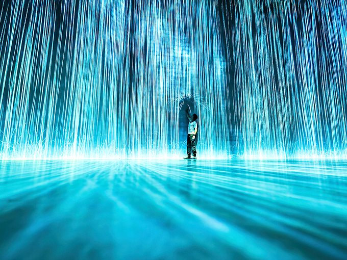 A solitary figure stands bathed in ethereal blue light, looking like they've just discovered the secret entrance to Atlantis's nightclub district.