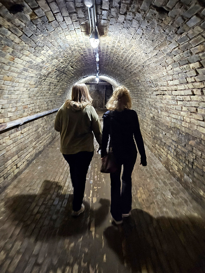 Visitors follow their guide through the brick-lined underground tunnels, where history feels tangibly close in the cool, musty air.