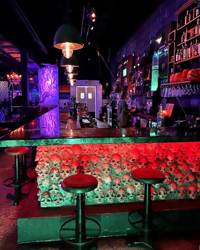The bar's signature feature: hundreds of illuminated skulls watching your every sip with an eerie red-green glow.