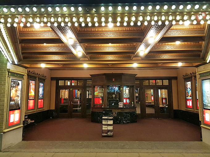The theater's entrance glows with the warm invitation of vintage bulbs, a portal between ordinary life and cinematic magic.
