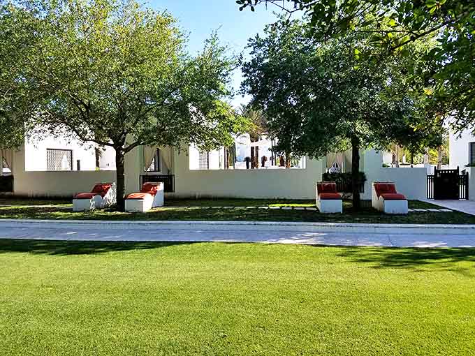 Manicured grounds and white walls create outdoor living spaces that blur the line between architecture and landscape in this coastal sanctuary.
