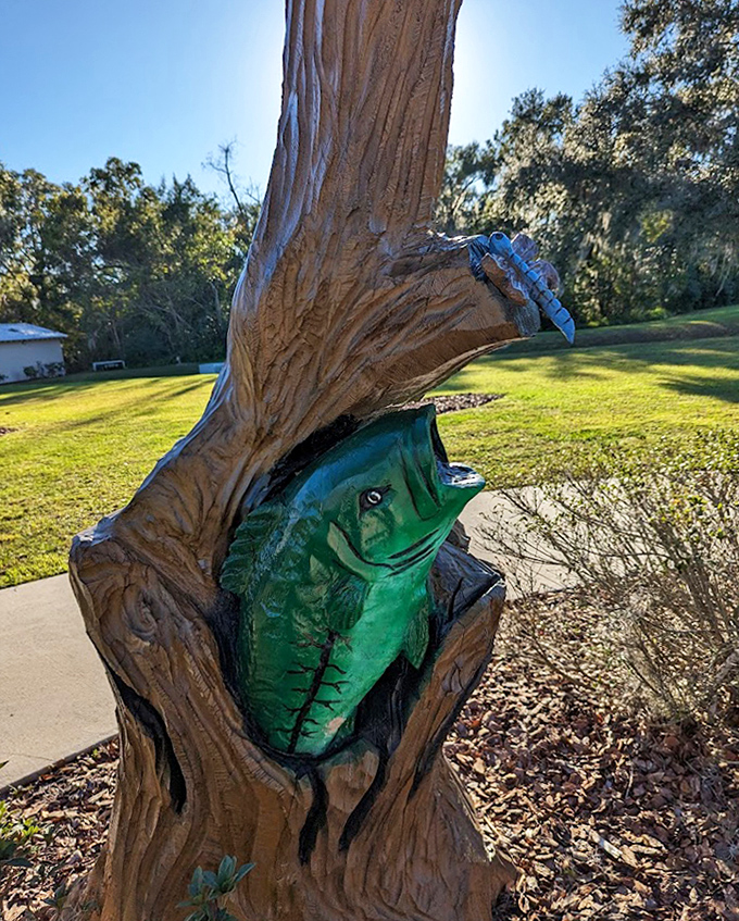A brilliantly green bass leaps from within the trunk, mouth agape as if caught mid-chase after an elusive minnow.