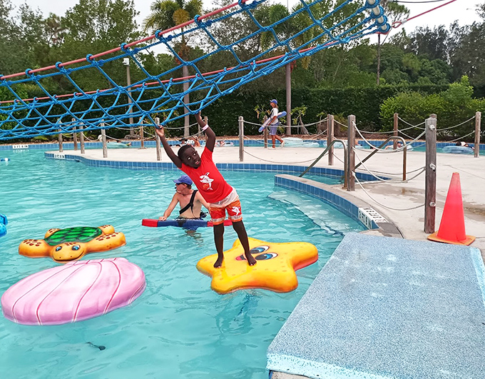 Colorful floating lily pads challenge young adventurers to test their balance while parents capture "future blackmail material" from the sidelines.